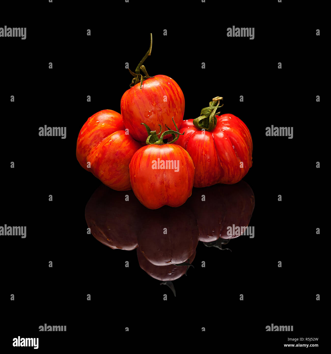 Pile tomato red-orange isolated on black Stock Photo - Alamy