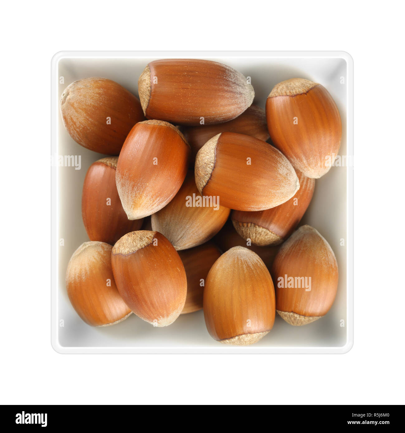 Hazelnuts in square bowl isolated on white background Stock Photo - Alamy