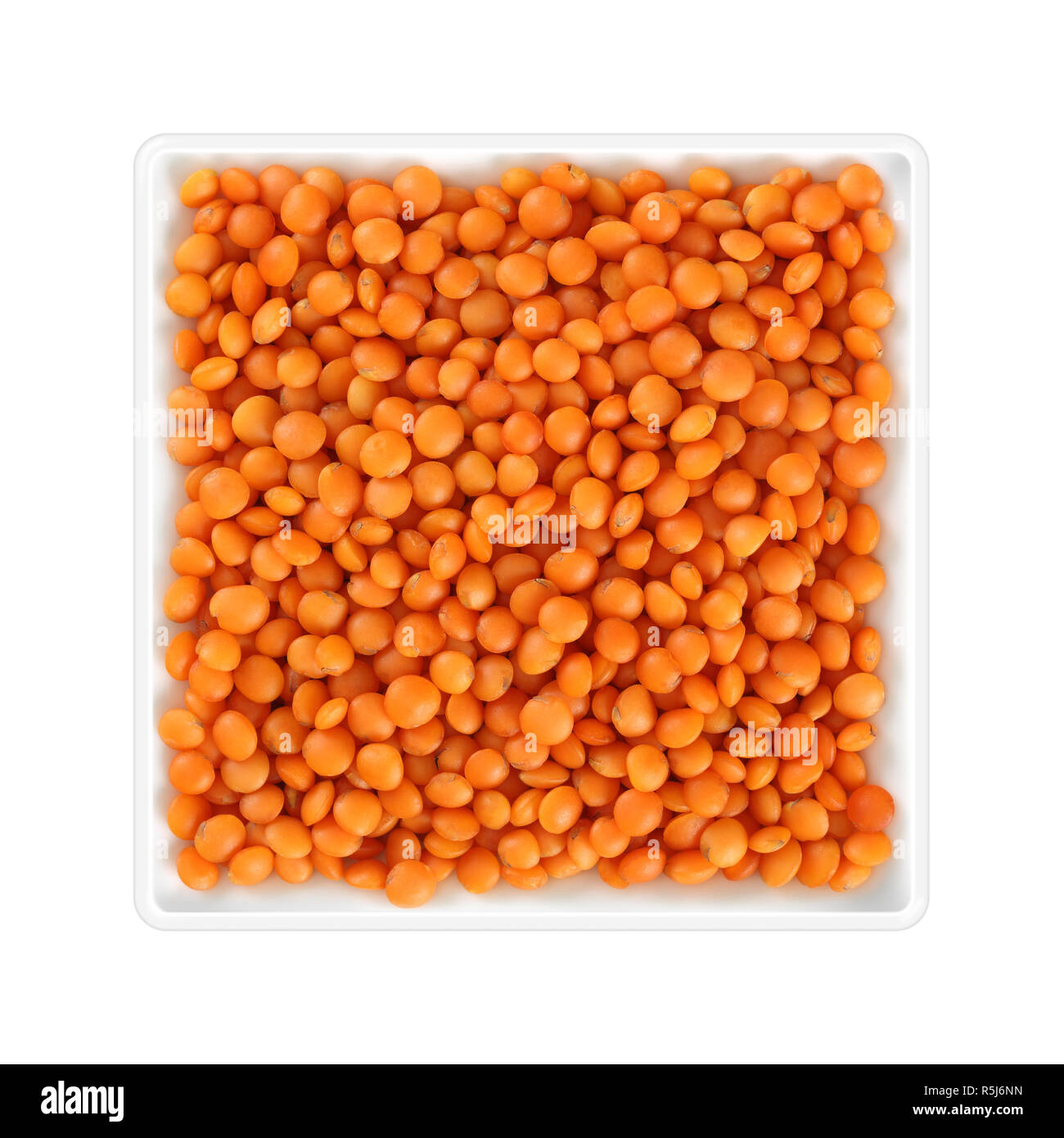 Red lentil in square bowl on white background Stock Photo - Alamy