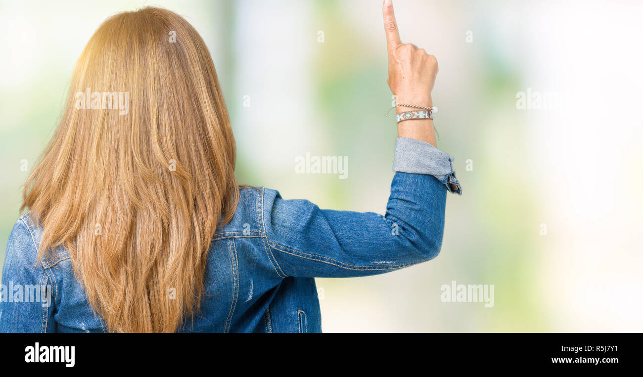 Beautiful middle age woman wearing casual denim jacket over isolated ...