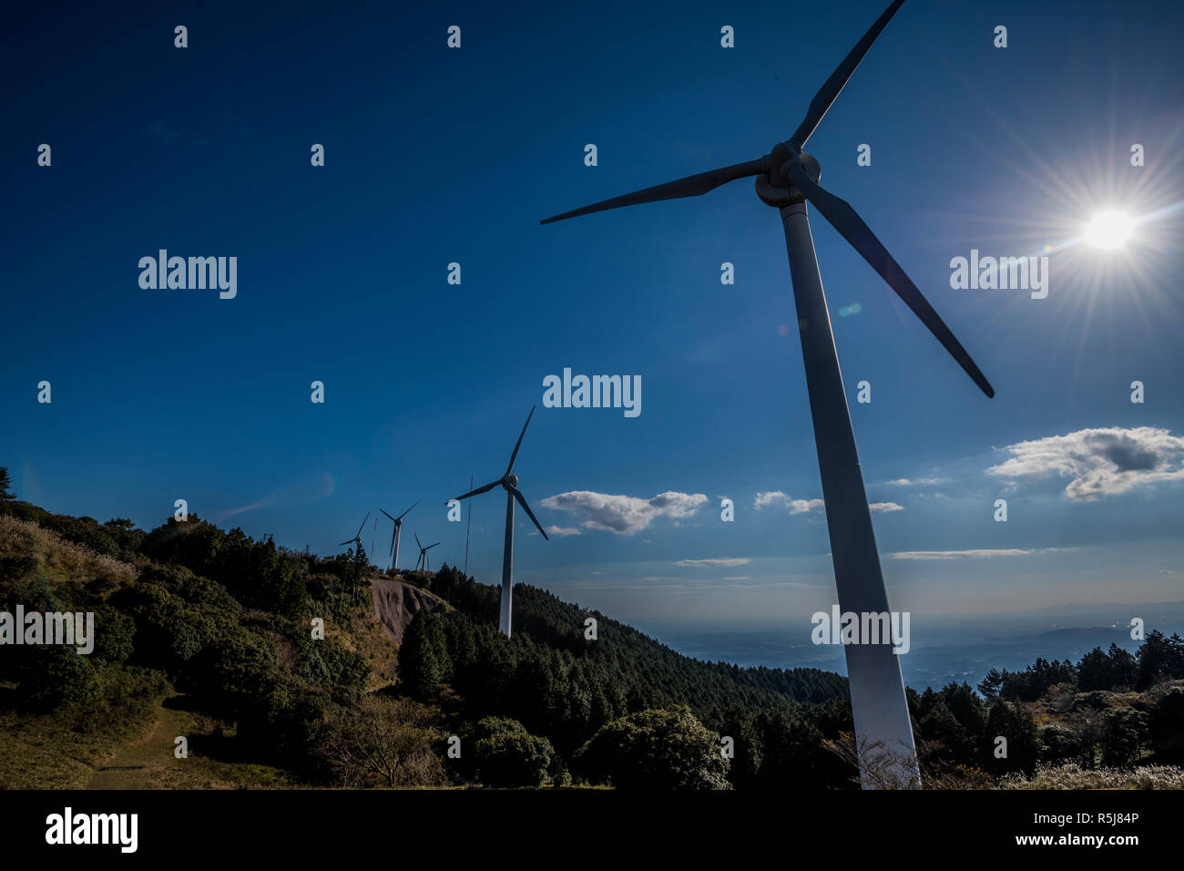 Wind power generators standing in the beam of the Sun. Aoyama plateau ...