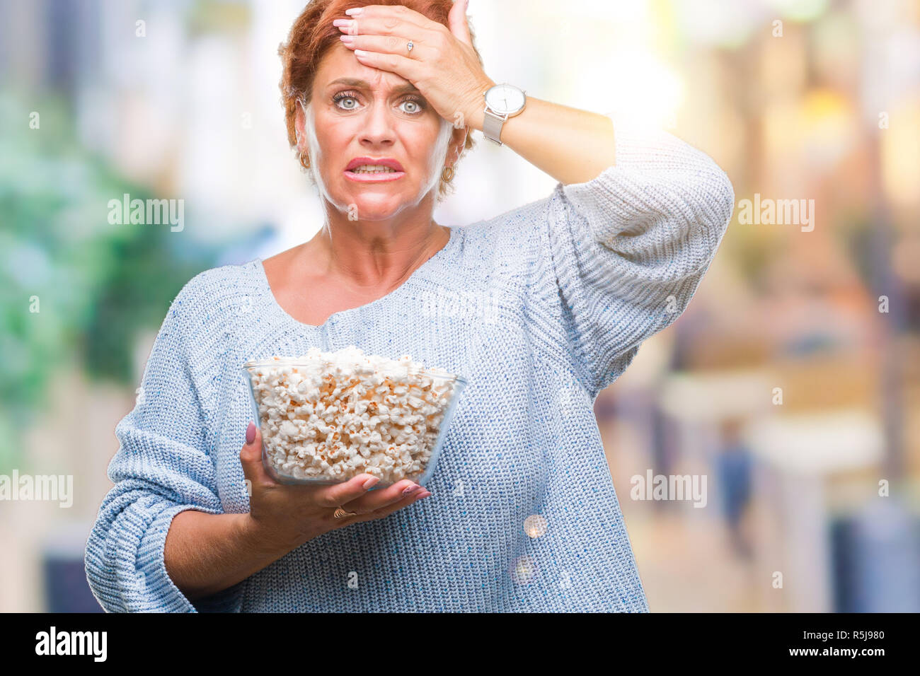 Atrractive Senior Caucasian Redhead Woman Eating Popcorn Over Isolated