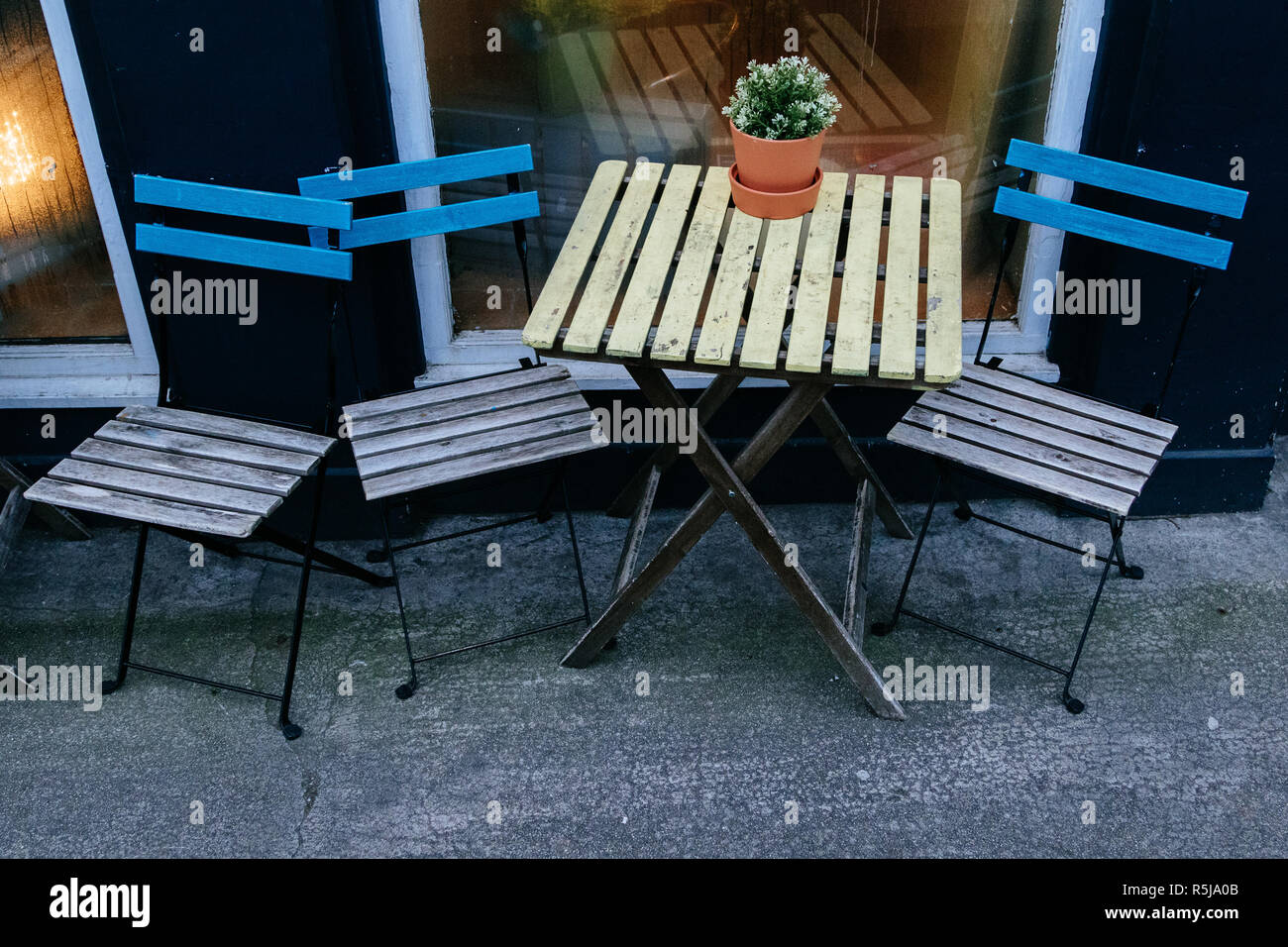 Wooden chairs and table standing outside a cafe Stock Photo - Alamy