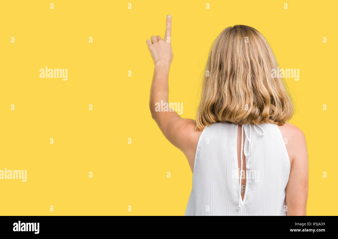 Beautiful young elegant woman over isolated background Posing backwards ...