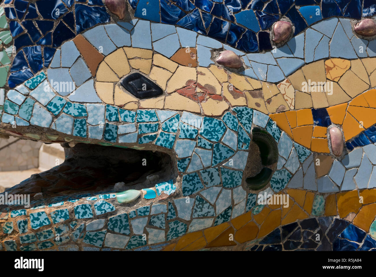 A decorative animal head made of colourful mosaic in the Park Guell ...