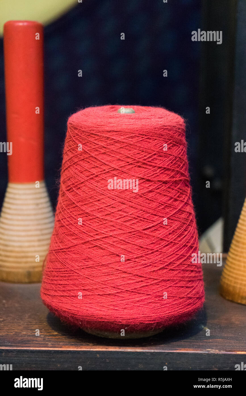 Red yarn thread on bobbin spool Stock Photo - Alamy