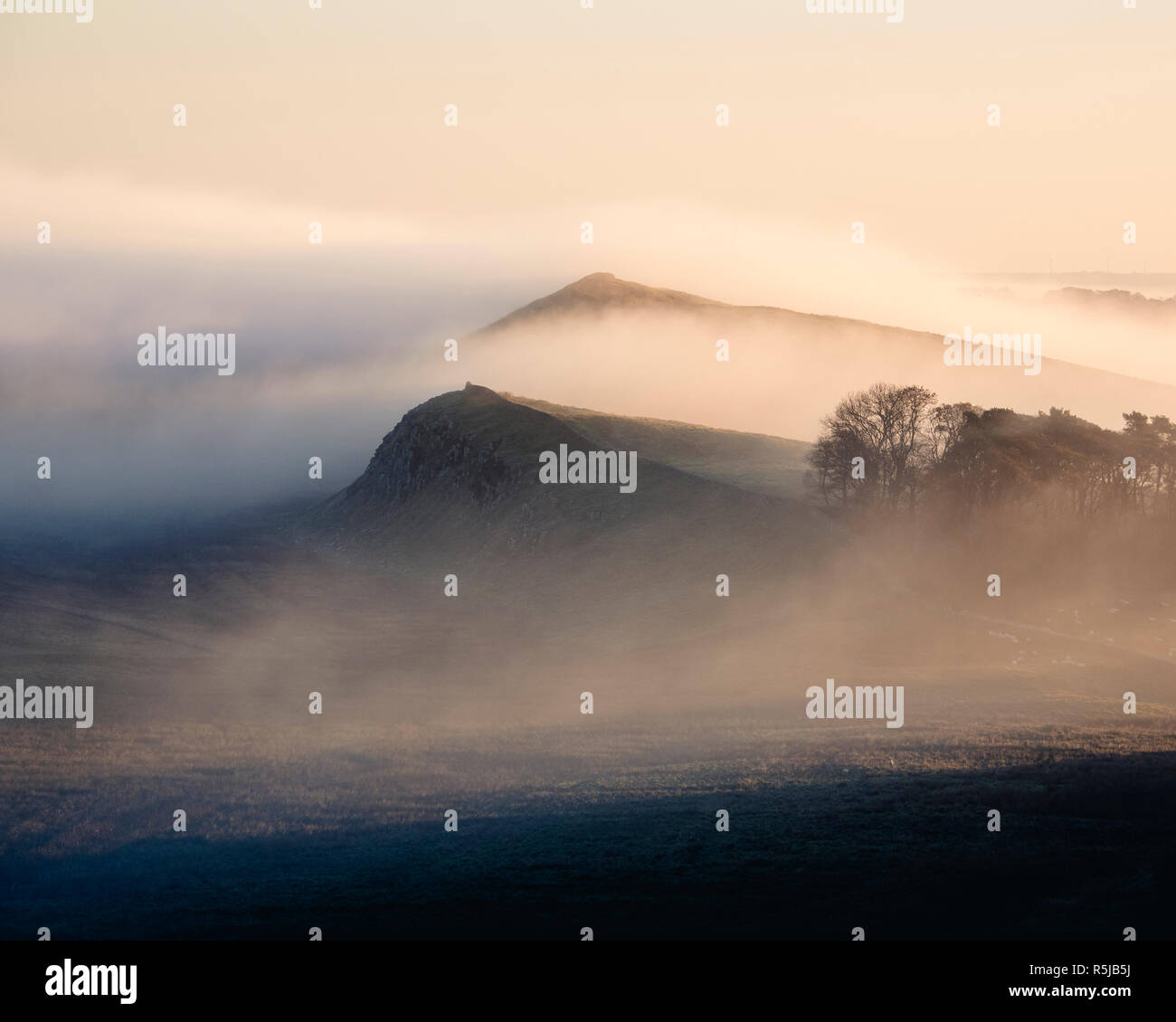 Mist rising over Hadrian's Wall as it runs cross the top of the Whin ...