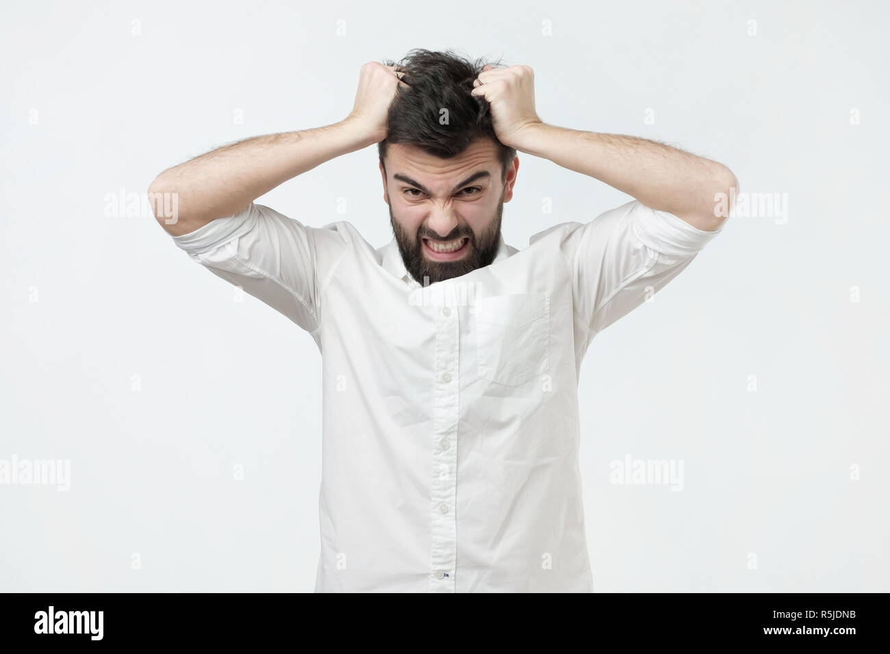 Angry and furious man on a gray background Stock Photo - Alamy