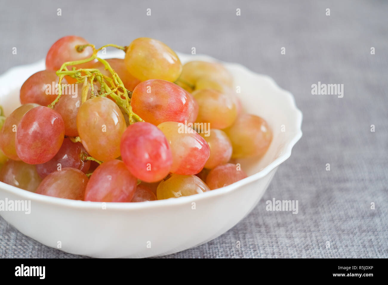 Grapes in a porcelain plate. Ripe pink Muscat grapes. Close up. Soft ...