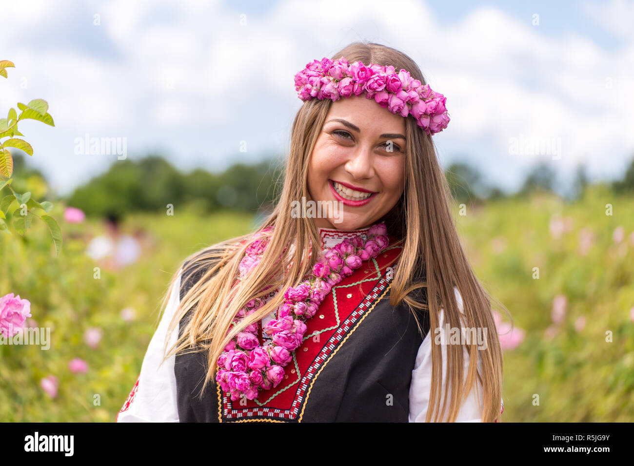 Bulgarian girl dressed in traditional dress picking roses during the ...