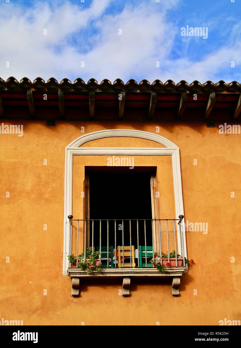 A large open window with yellow and green wooden chairs Stock Photo - Alamy