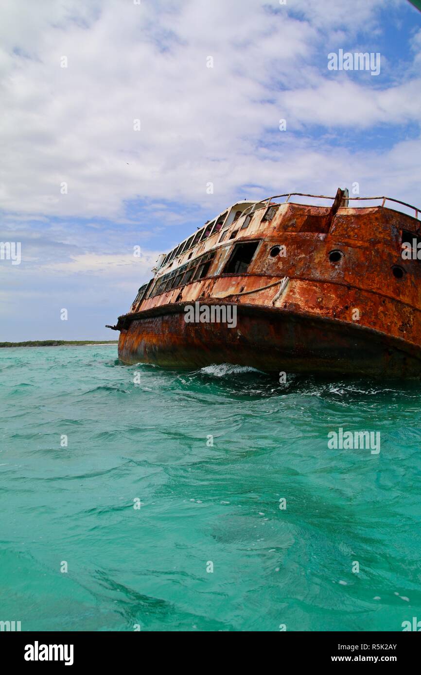 Rusted shipwreck on it's side in shallow Caribbean waters wrecked by a ...