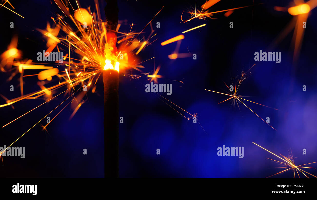 Sparkler Over Blue. Gun powder sparks shot against deep dark background ...