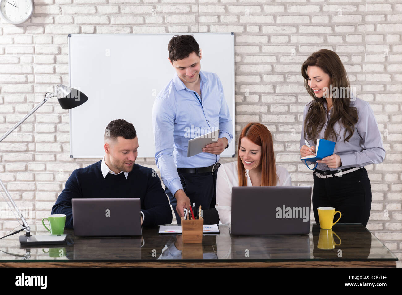 Happy Business People Doing Work At Workplace Stock Photo - Alamy