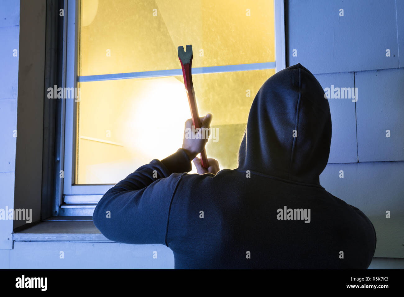 Robber Using The Crowbar To Open The Glass Window Stock Photo - Alamy