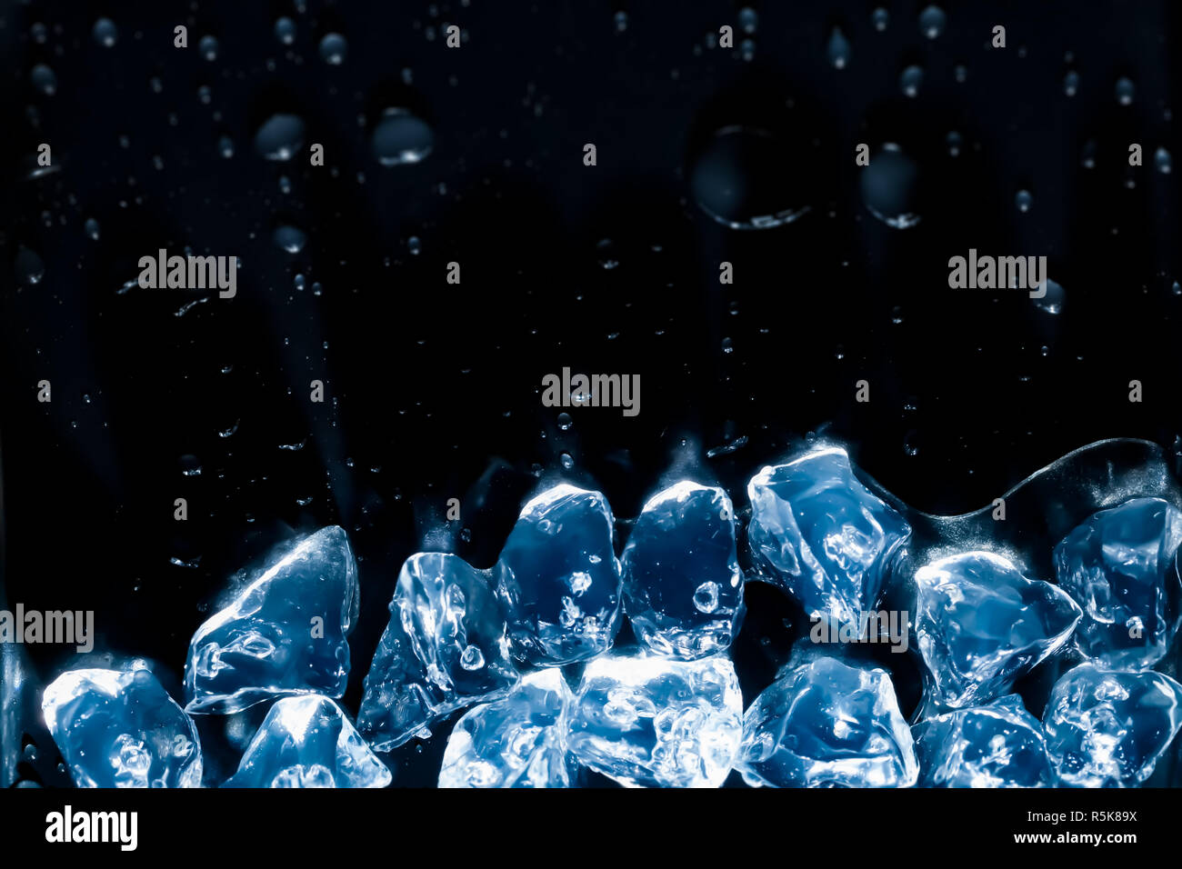 Ice cubes melting in water abstract Stock Photo - Alamy
