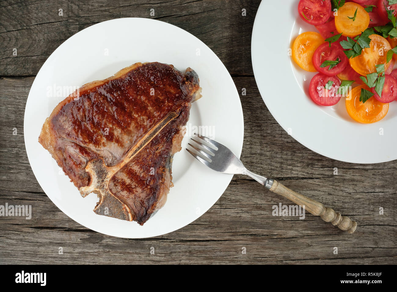 porterhouse steak fried with tomato salad Stock Photo - Alamy