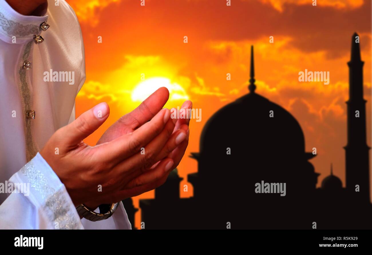 Praying hands with sunset background Stock Photo - Alamy