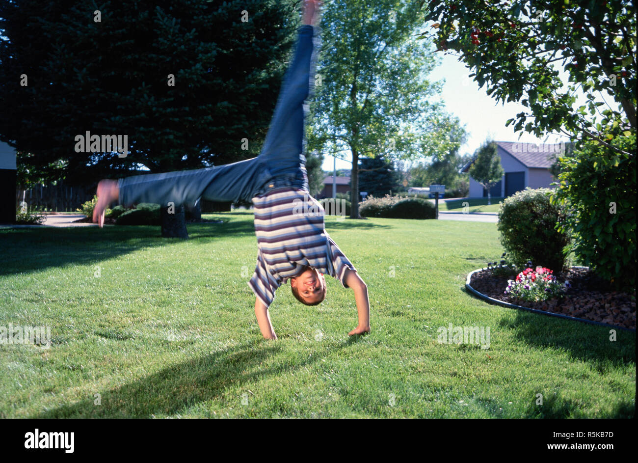 Young boy performs cartwheel on suburban lawn, Montana, USA Stock Photo ...