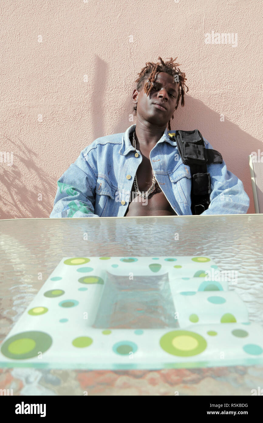 Man sitting behind a table on which there is a vintage style ashtray ...