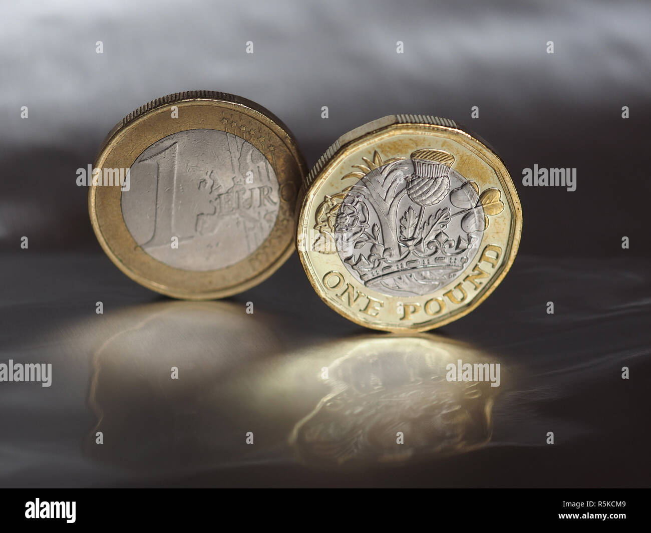 1 pound and 1 euro coin over metal background Stock Photo - Alamy