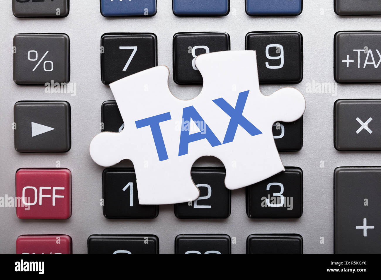 Jigsaw Puzzle Piece With Tax Text On Calculator Stock Photo - Alamy