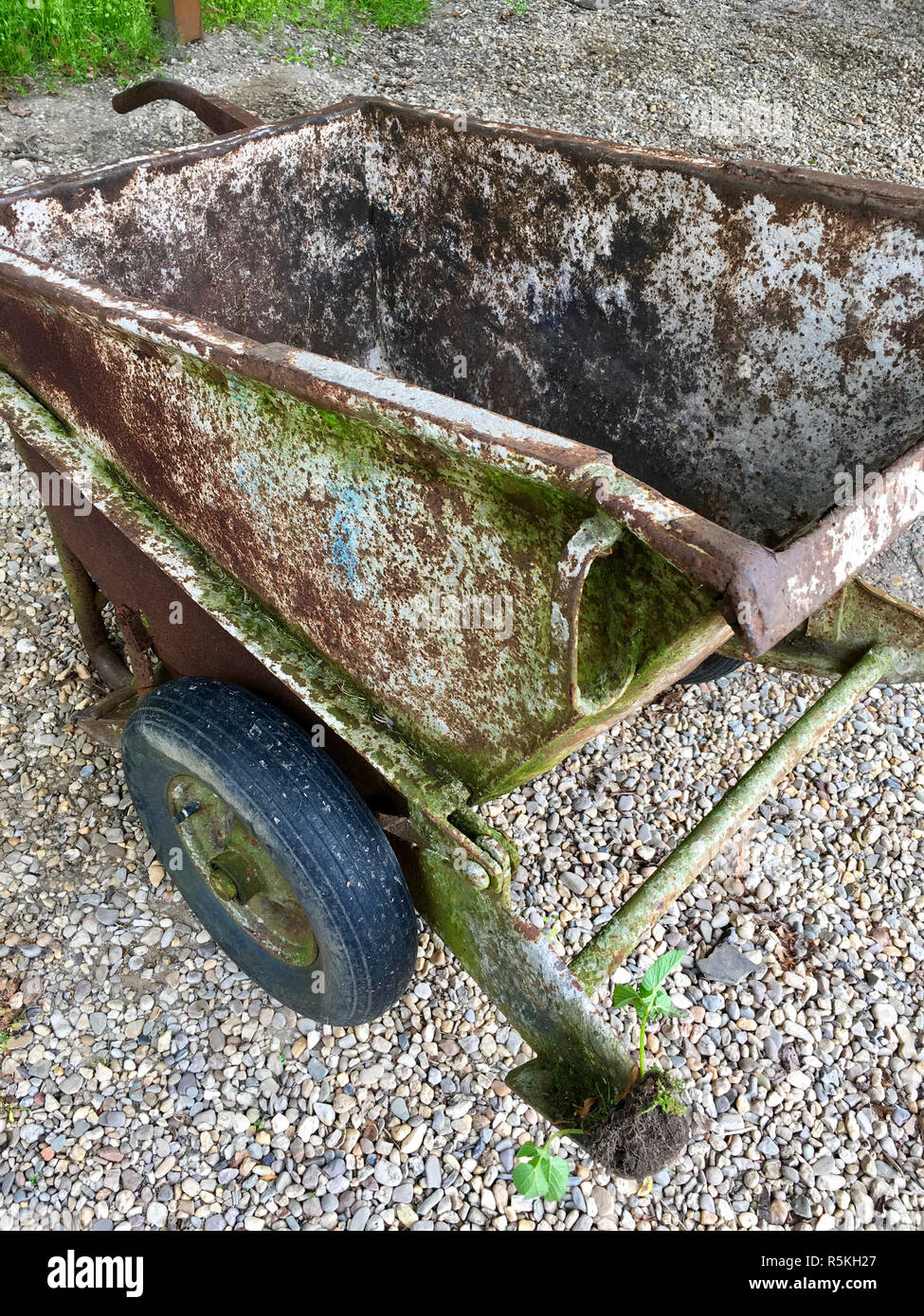 very old and rusty wheelbarrow for garden waste Stock Photo - Alamy