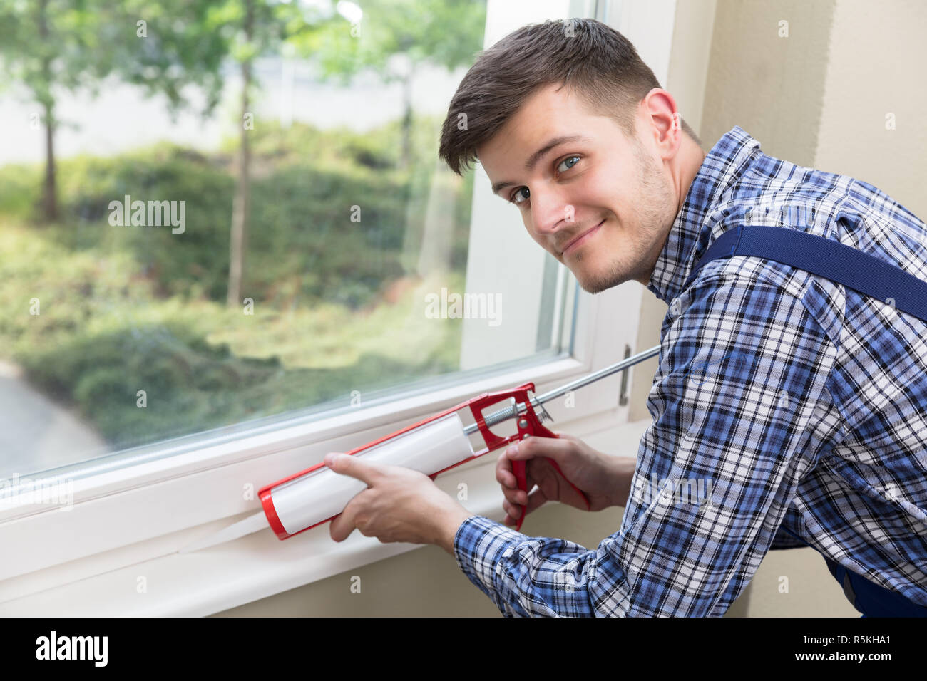 Worker Applying Silicone Sealant With Silicone Gun Stock Photo - Alamy