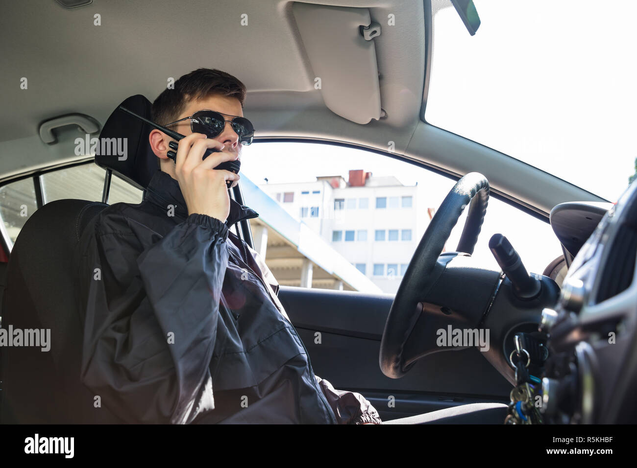 Private Detective Talking On Walkie Talkie Stock Photo - Alamy