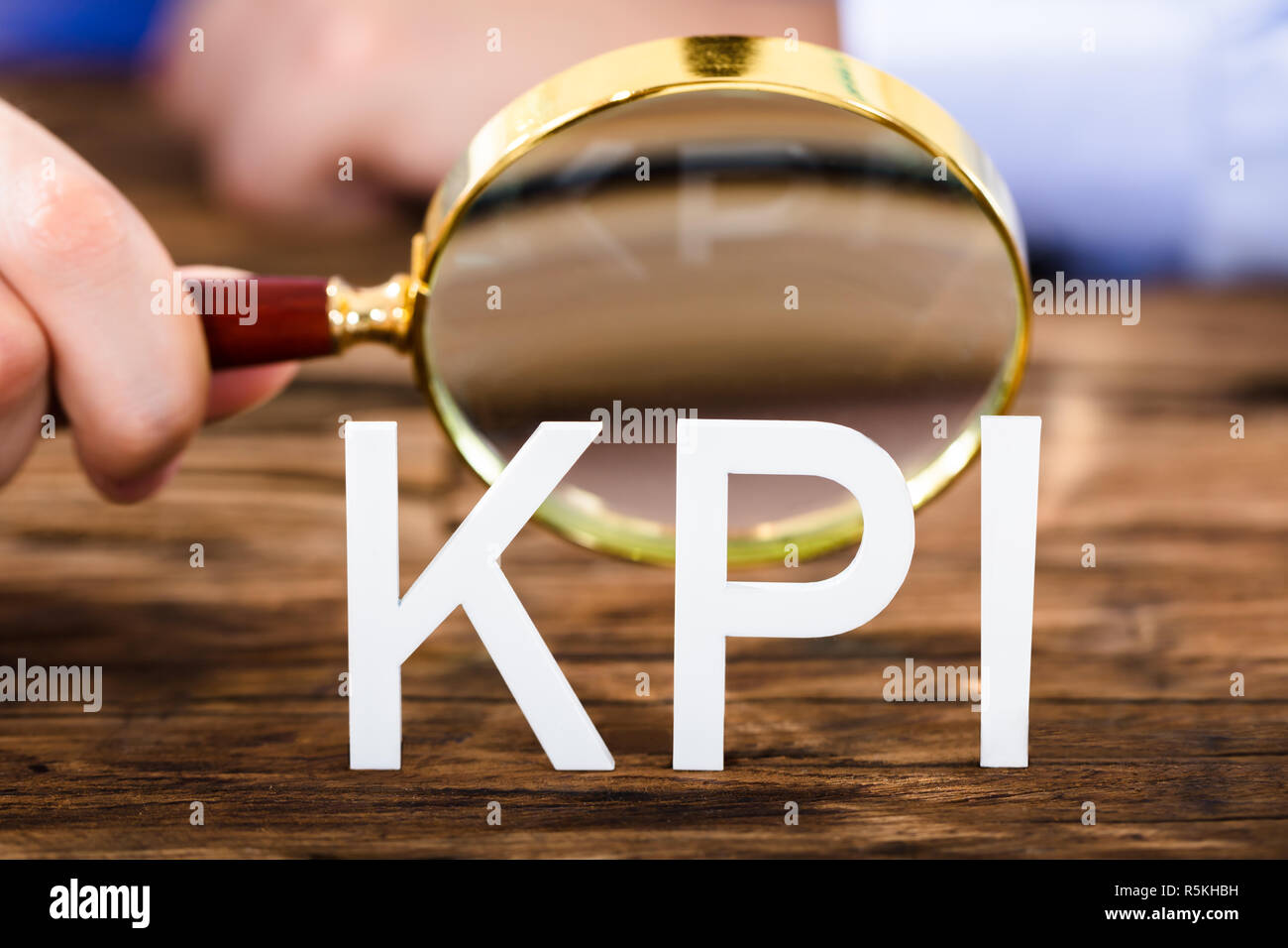 Hand Examining Key Performance Indicator With Magnifying Glass Stock ...