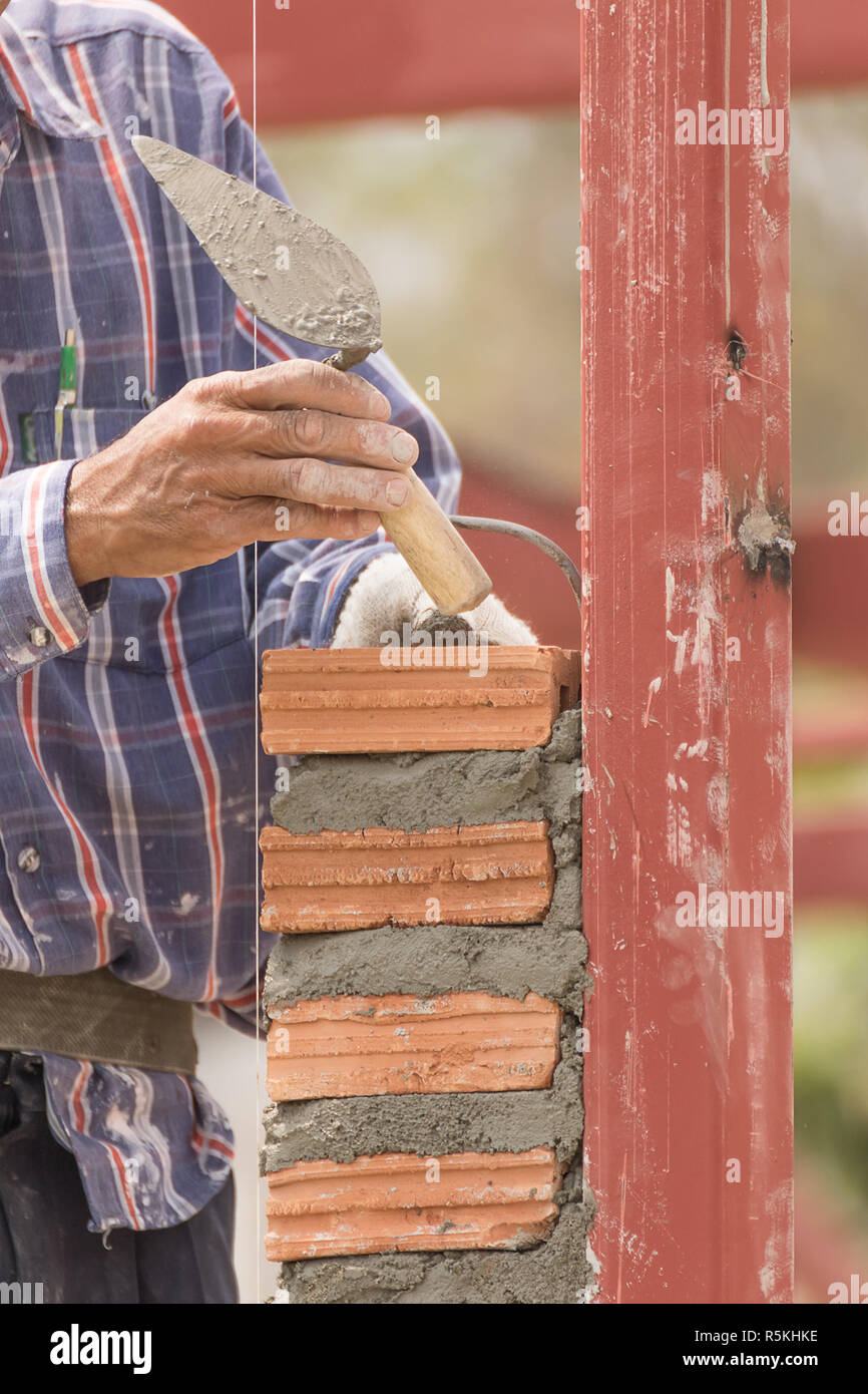 Bricklayer working in construction site of brick wall Stock Photo - Alamy