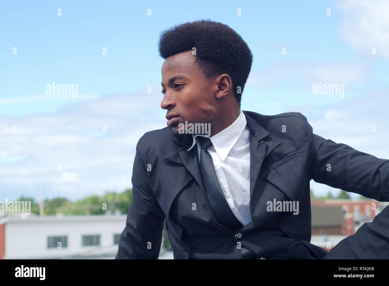 young businessman sitting building roof suit and tie Stock Photo - Alamy