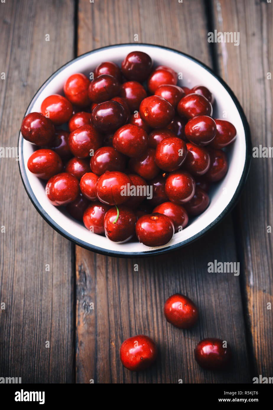 Ripe red cherry in an iron bowl Stock Photo - Alamy