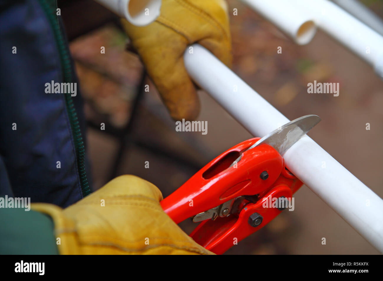 Man cutting PVC pipe Stock Photo - Alamy
