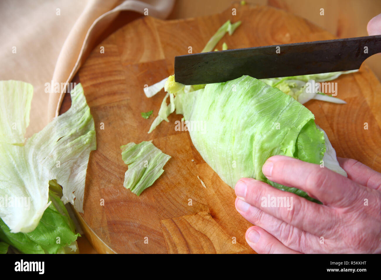 Man cuts up lettuce wedge Stock Photo - Alamy