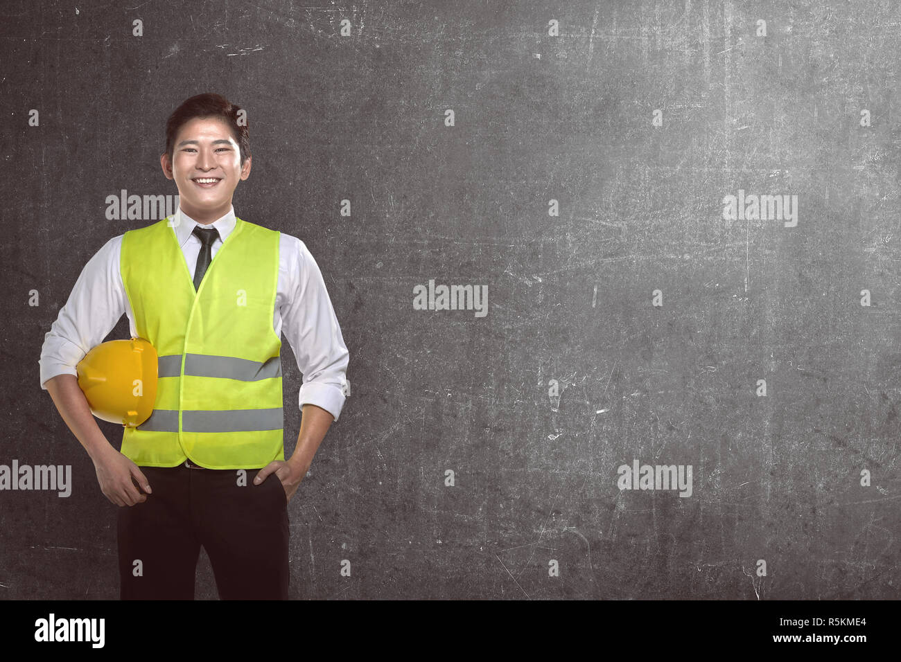 Asian worker wearing safety vest and yellow helmet Stock Photo - Alamy