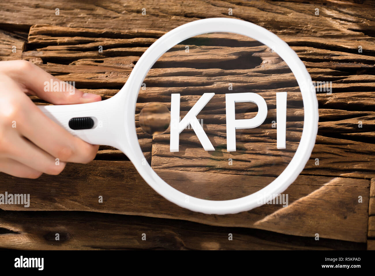 Hand Examining Key Performance Indicator With Magnifying Glass Stock ...
