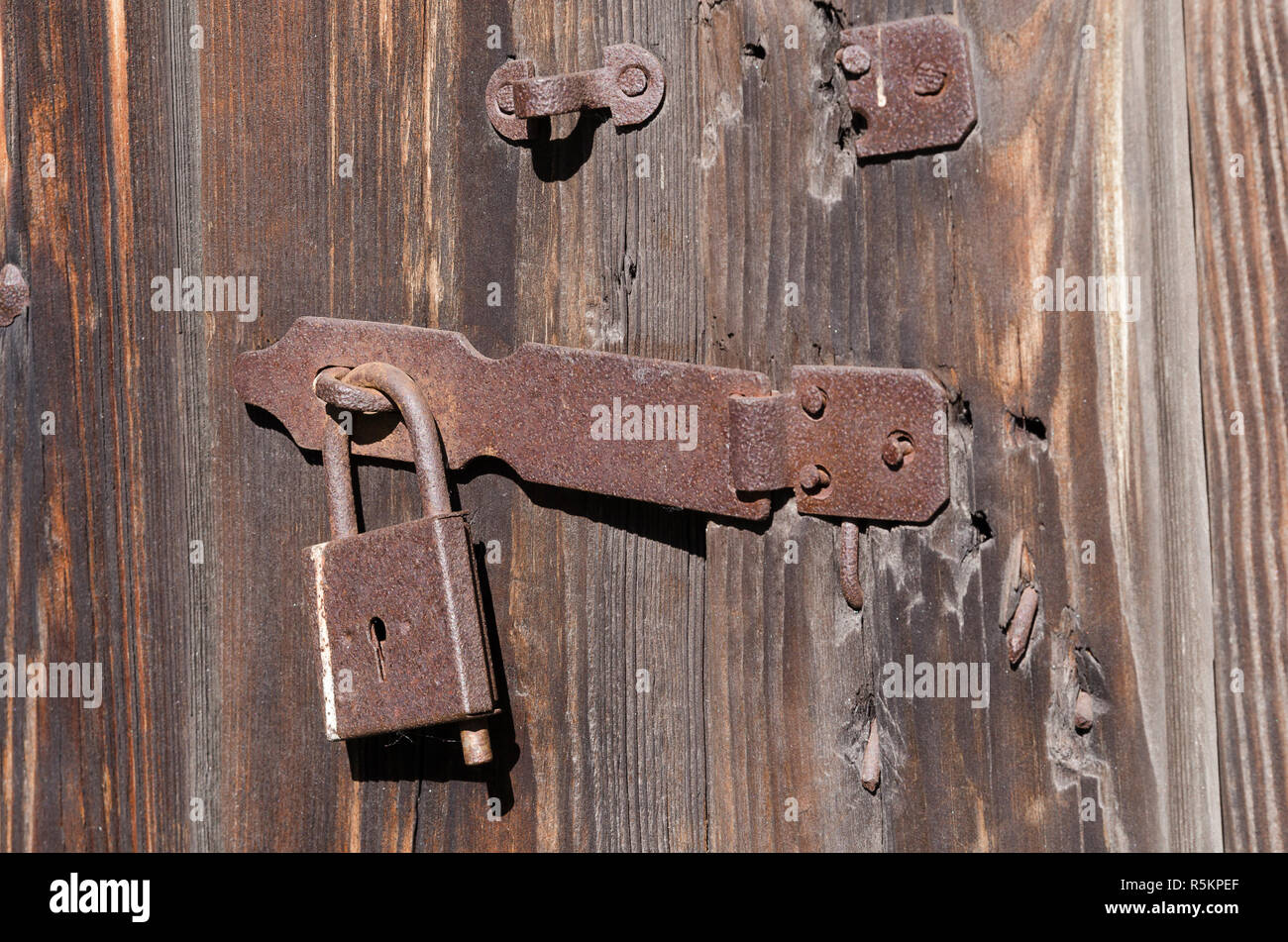 Iron lock on metal fastening hanging on wooden gate Stock Photo - Alamy