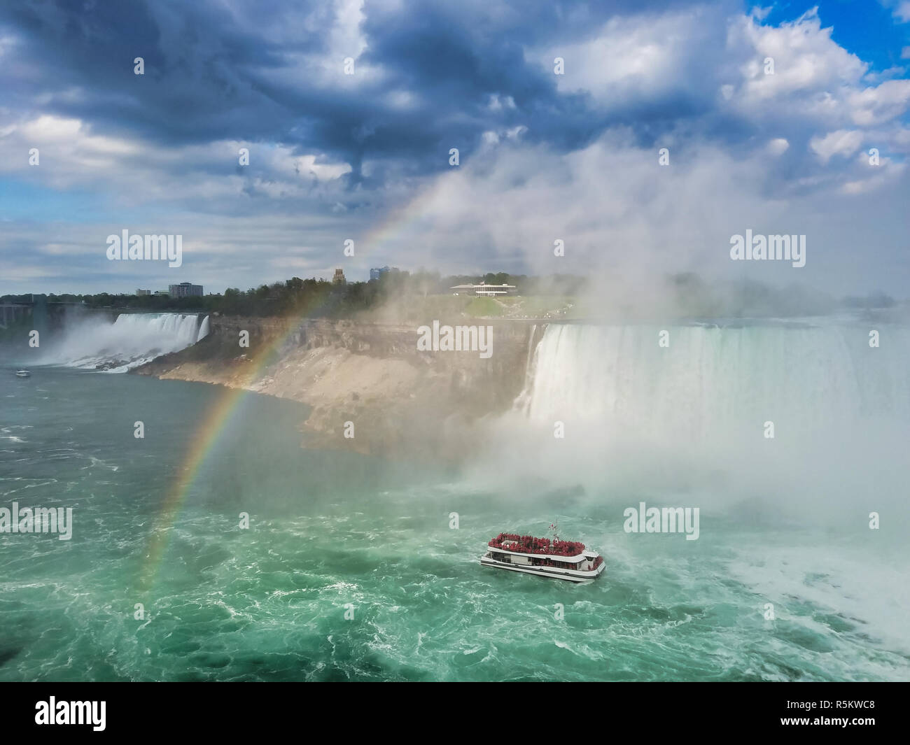The boat surrounded by mist under Niagara waterfalls passing under the ...