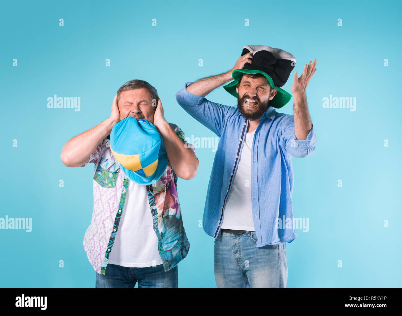 The two football fans singing the national anthem over blue Stock Photo ...