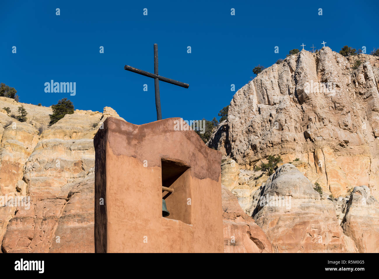 Bell tower and rustic wood cross of Abbey Church and colorful cliffs at ...