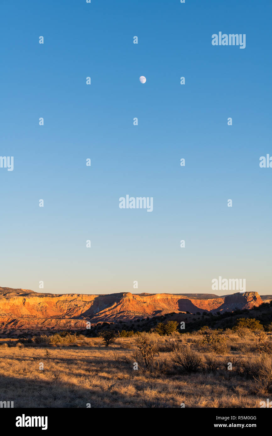 Moon over a colorful desert landscape at dusk over Ghost Ranch in ...