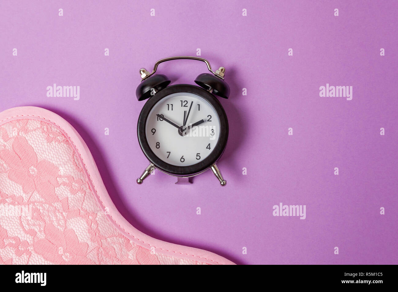 Sleeping eye mask, alarm clock isolated on purple violet pastel ...