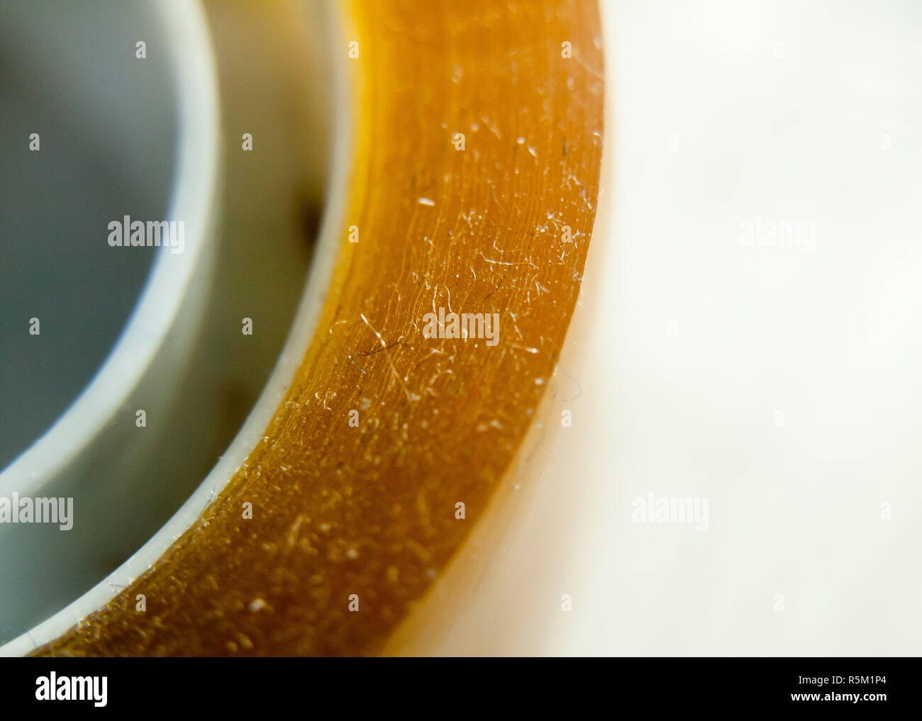 extreme close up of yellow sticker tape cellophane on white background ...