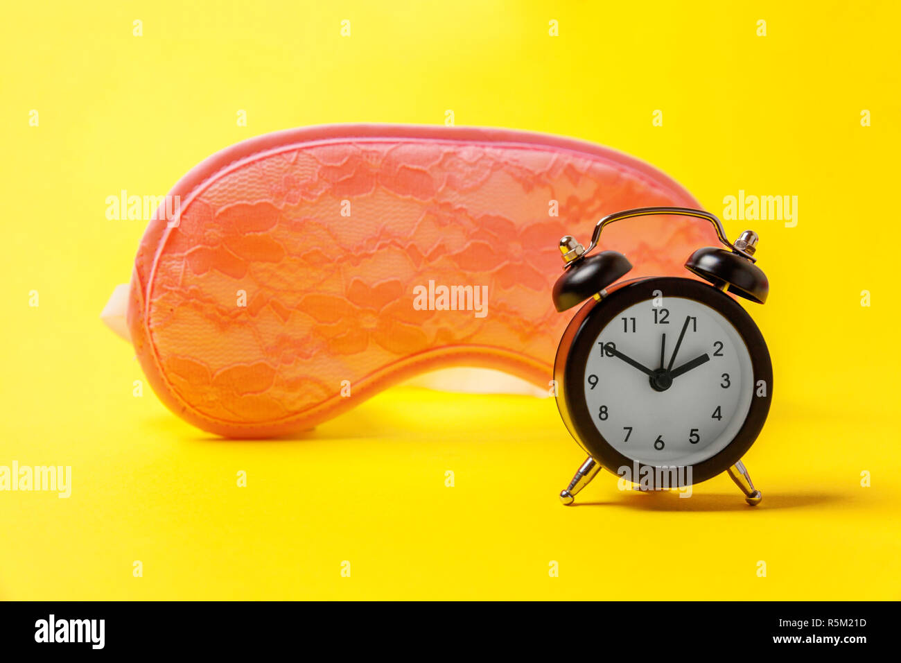 Sleeping eye mask, alarm clock isolated on yellow colourful trendy ...