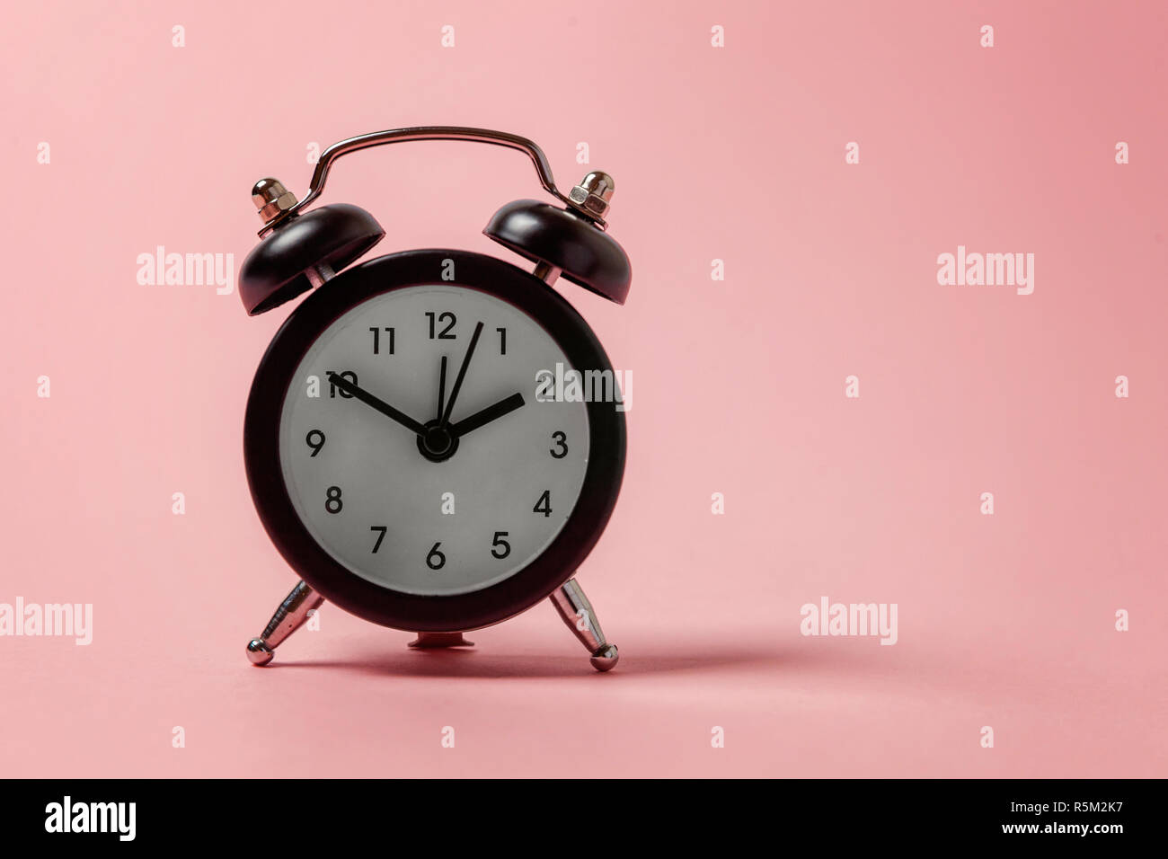 Ringing twin bell vintage classic alarm clock Isolated on pink pastel ...