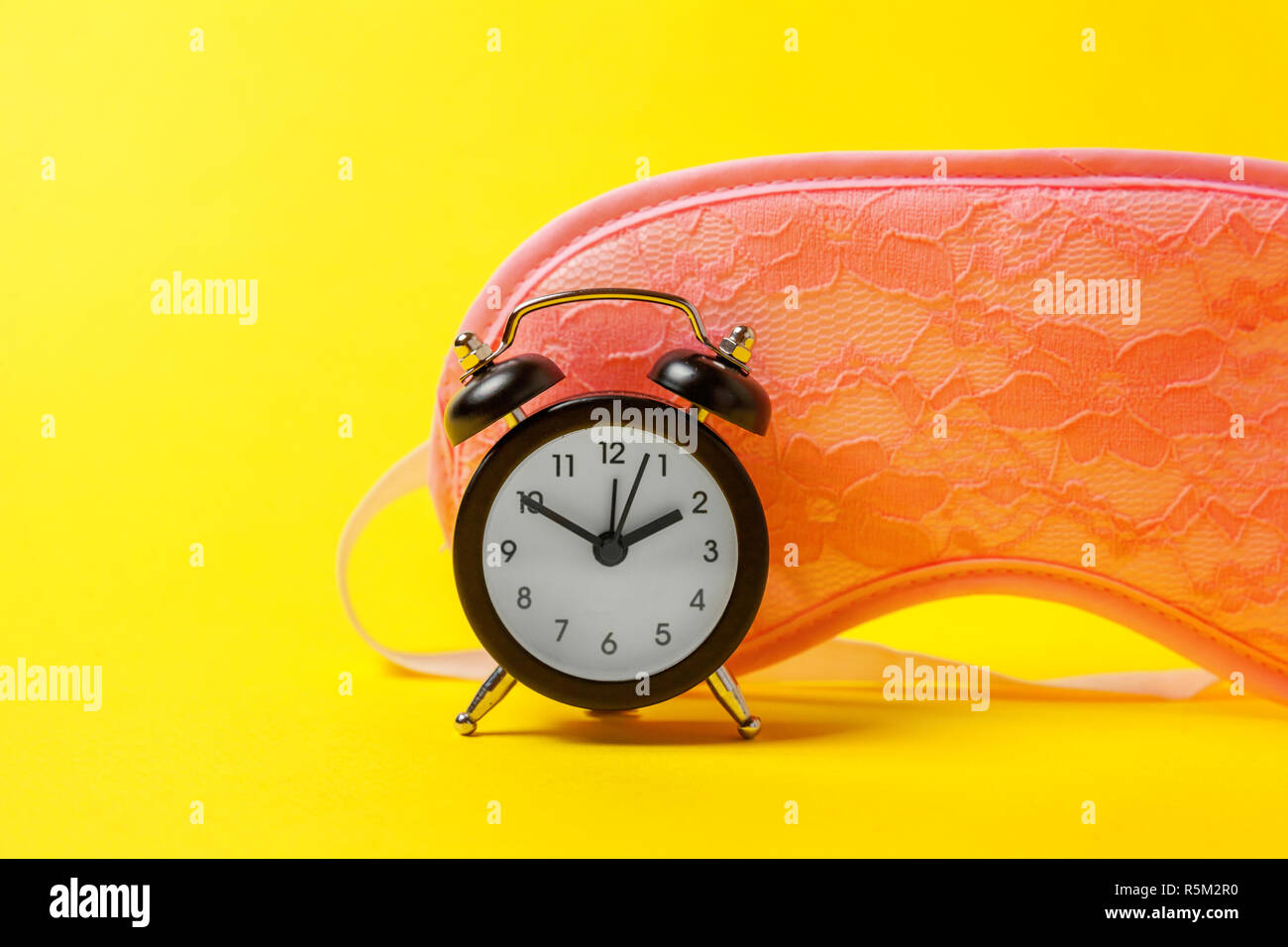 Sleeping eye mask, alarm clock isolated on yellow colourful trendy ...