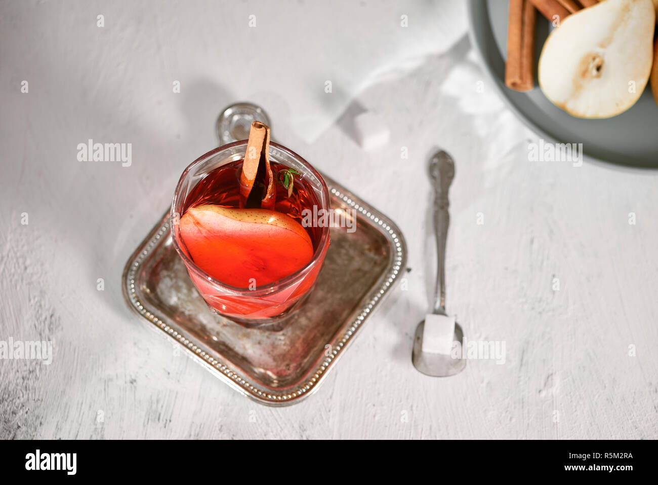 Homemade hot sliced pear with a cinnamon stick on a white background ...
