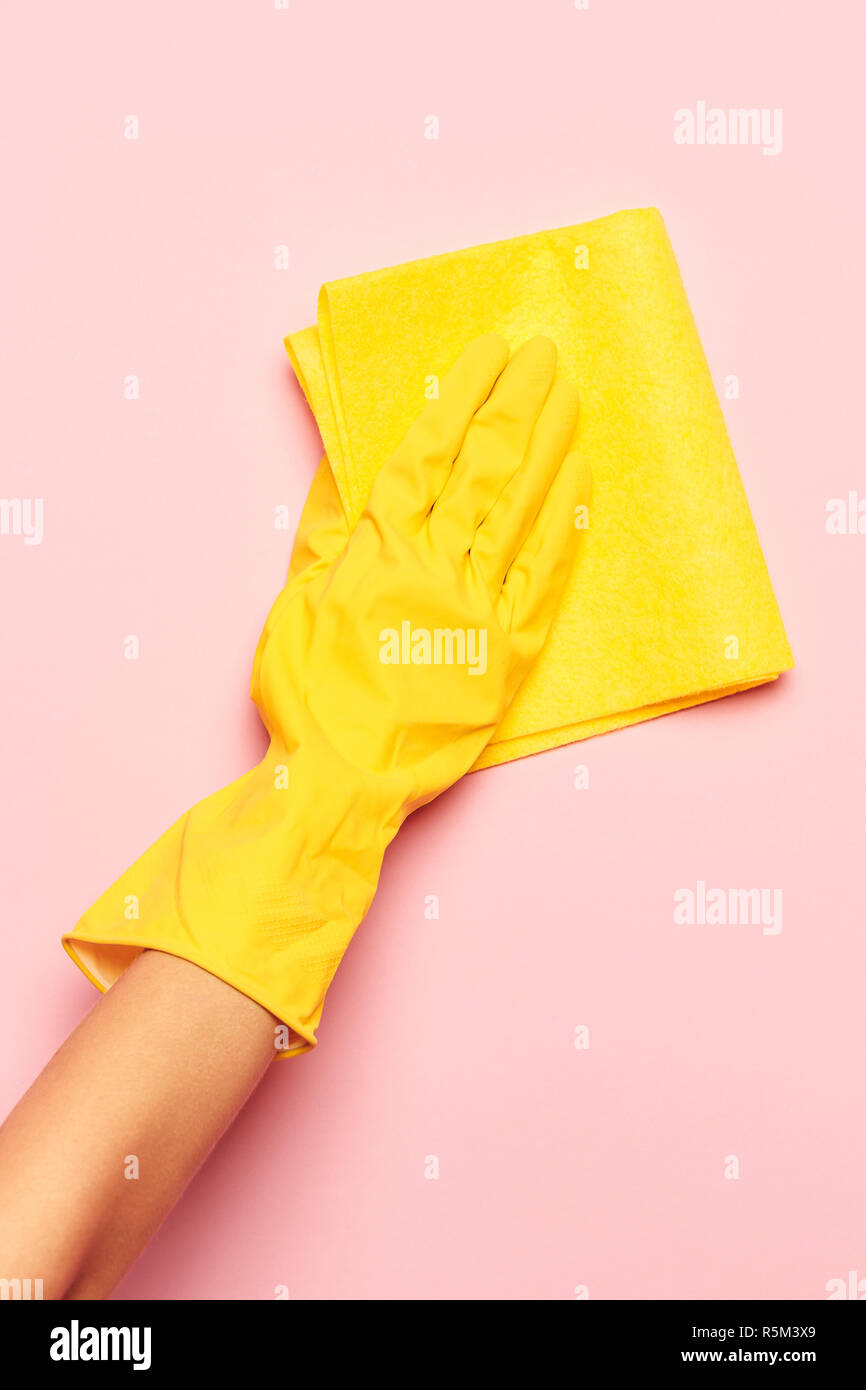 The woman's hand cleaning on a pink background. Cleaning or ...