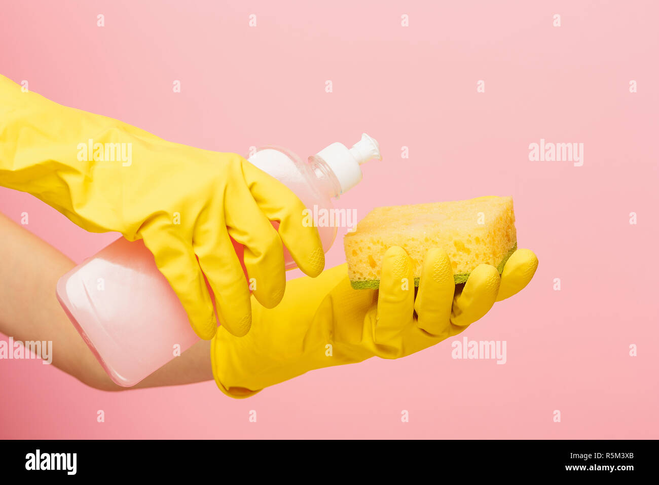 The woman's hand cleaning on a pink background. Cleaning or ...